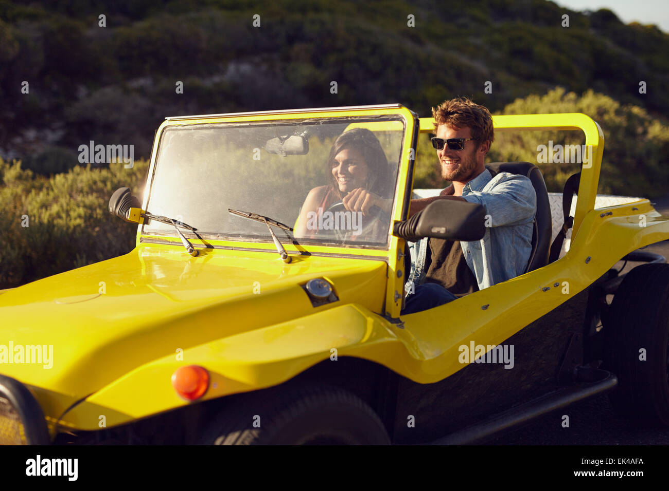 Shot of a handsome young man driving a buggy car in the countryside ...