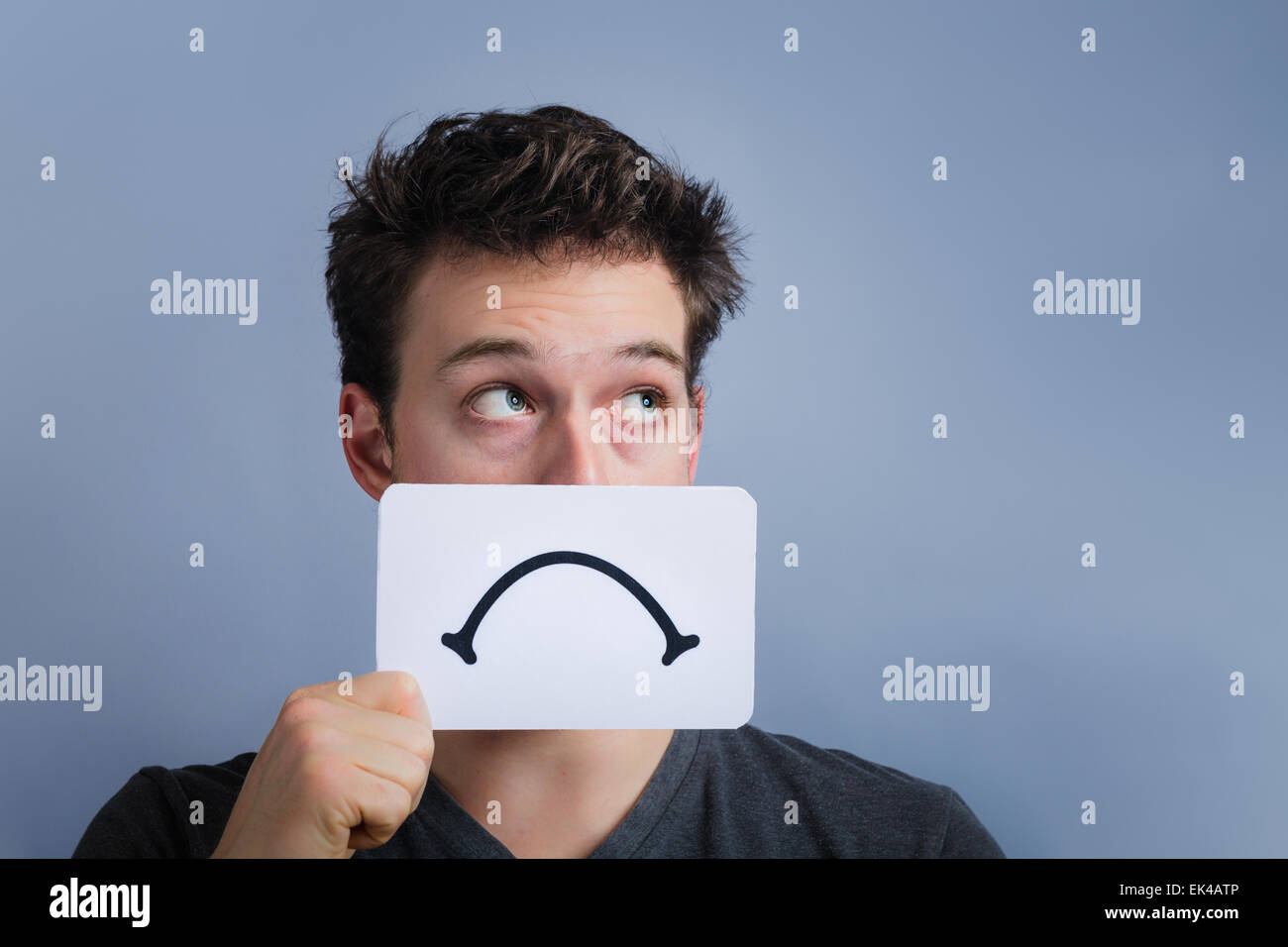 Unhappy Portrait of a Man Holding a Sad Mood Board with Blue Background ...
