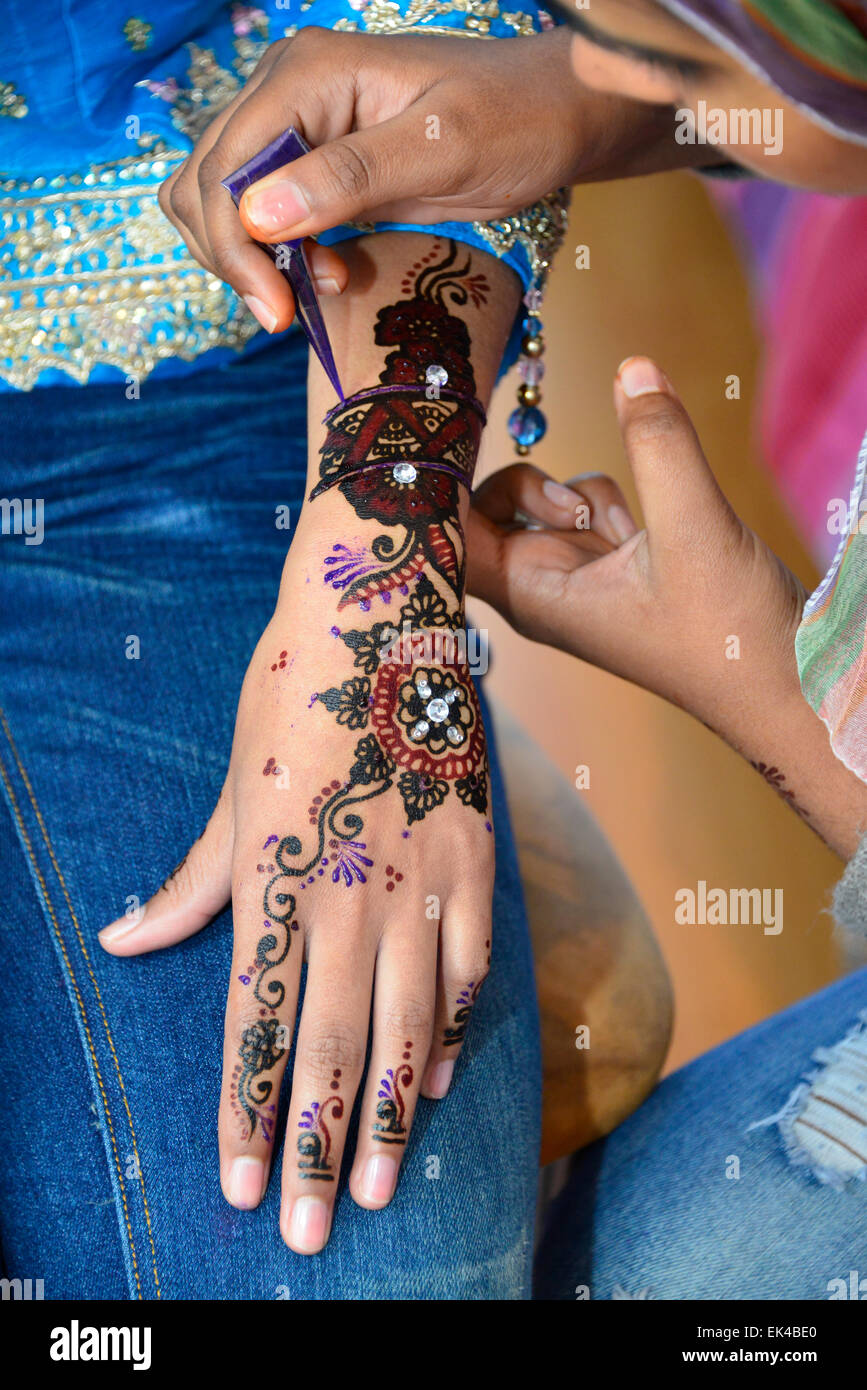 Henna being painted on the hand of a young lady about to get engage to ...