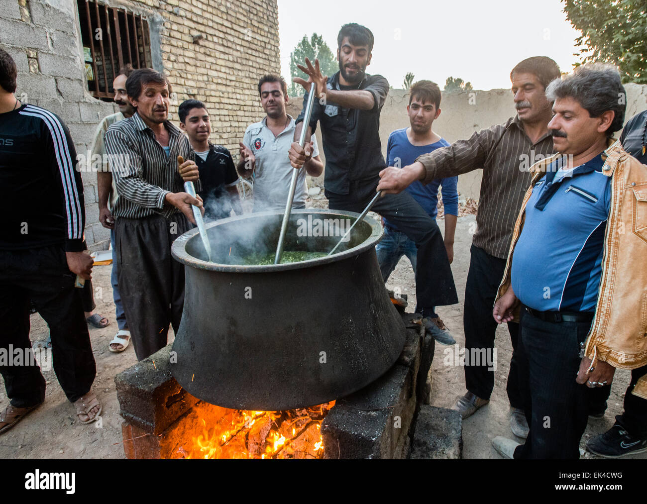Men serves ritual lunch soup with beans, threads and vegetables for ...