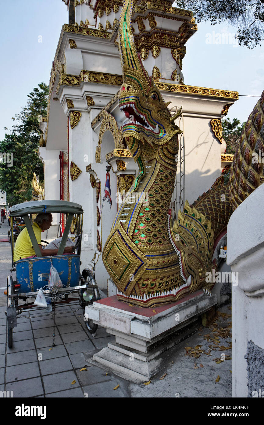 Thailand, Chiang Mai, a rickshaw parked by a religious dragon statue ...