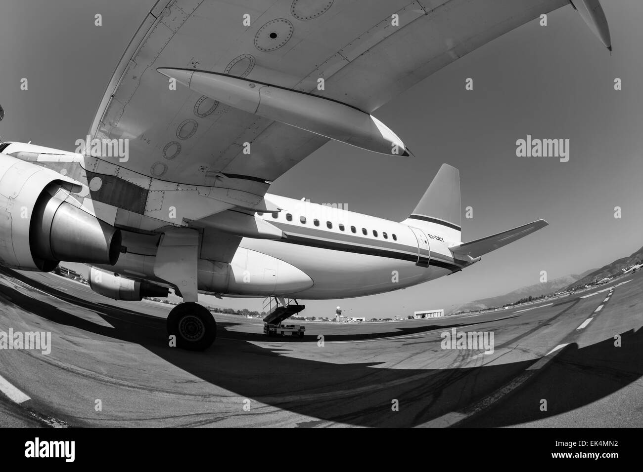 Italy, airplane on the runway and flight control tower in the ...