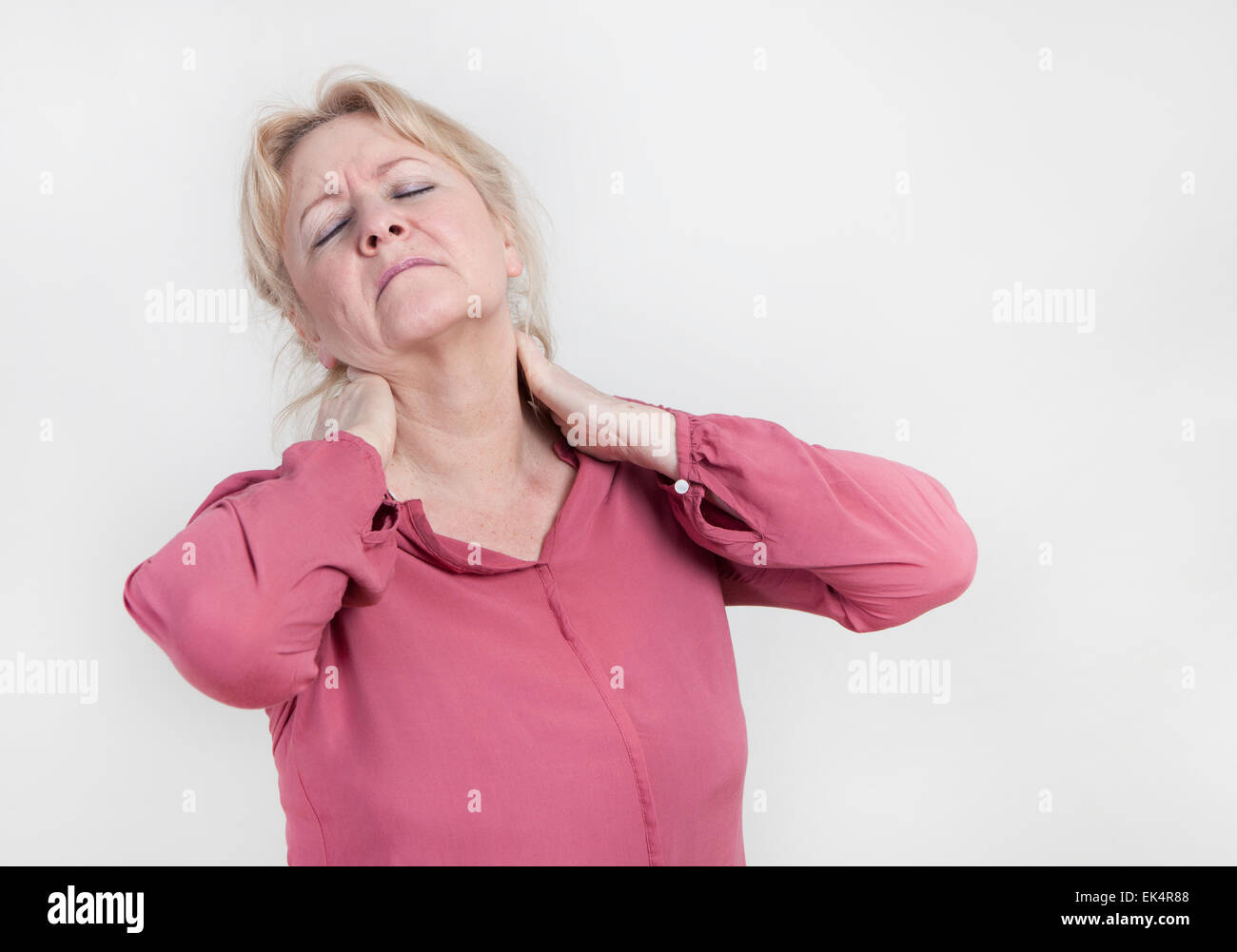 an older blonde woman holding his neck with her hand Stock Photo - Alamy
