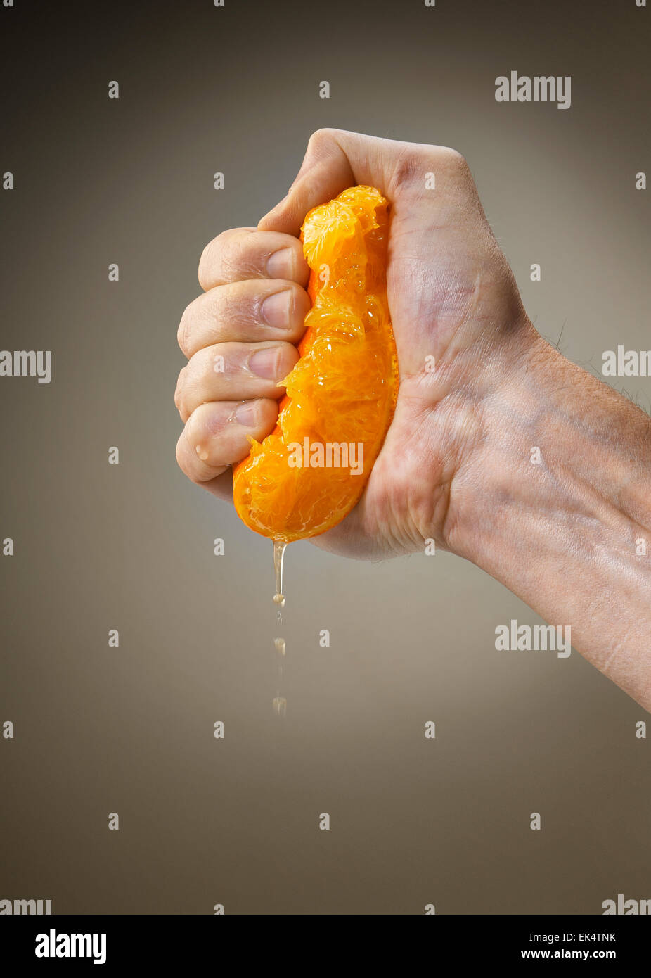 Fresh Squeezed Orange Juice by male hand and juice falling with ...