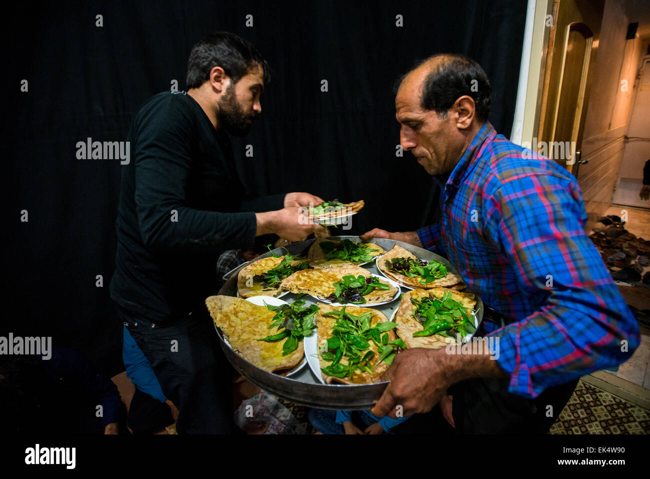 Participants of Tazieh, ritual theater of the day of Ashura, eat beryun ...