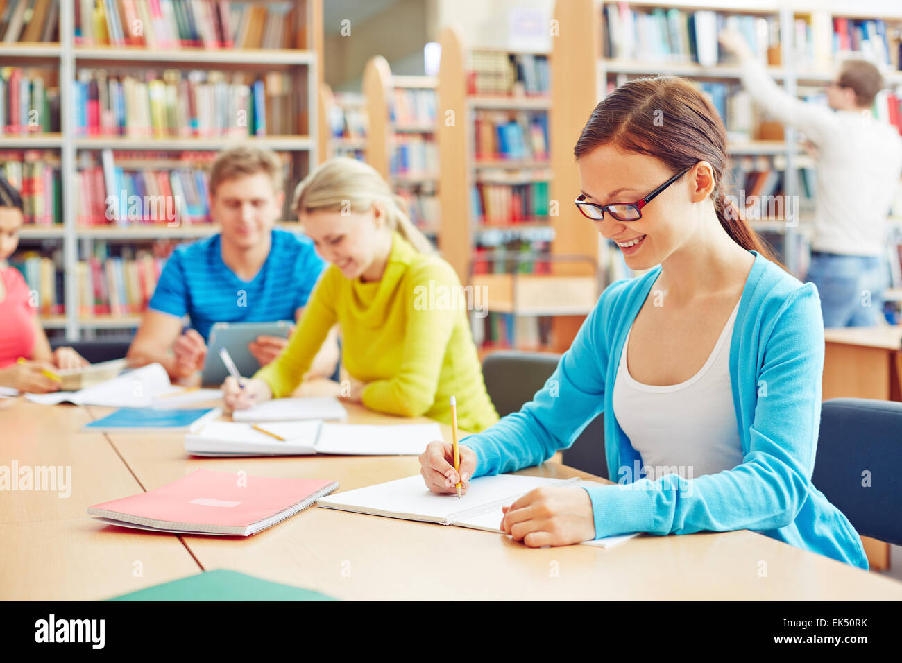 Pretty student making notes in college library Stock Photo - Alamy