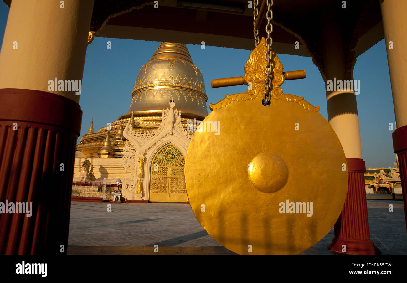 Golden gong of a Buddhist temple framed in an temple arch set against a ...
