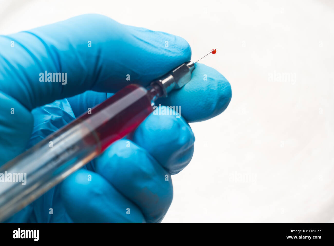 suggestive of body fluid and serum red liquid inside a syringe taken as ...