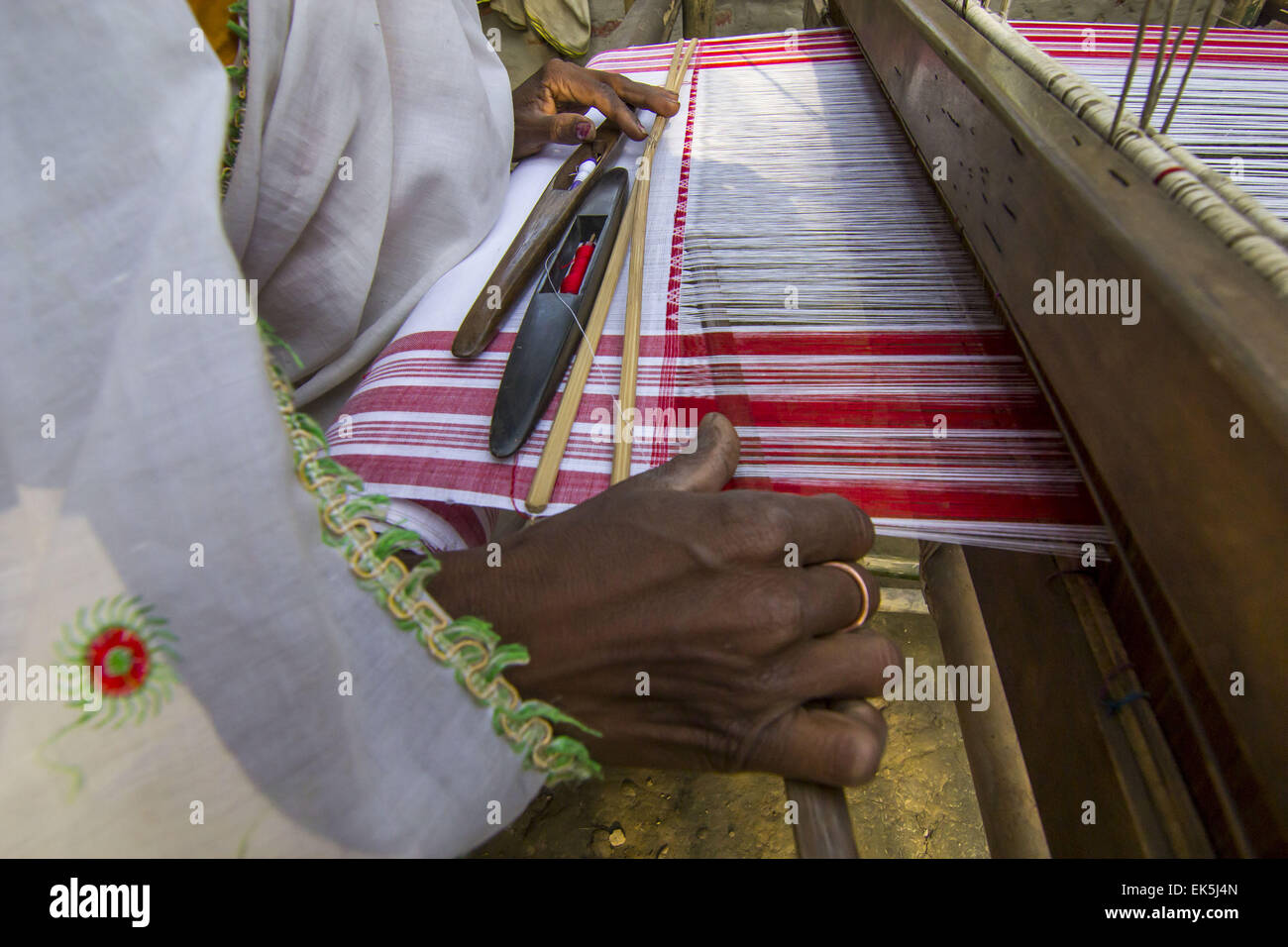 Sivasagar, Assam, India. 7th Apr, 2015. A woman weaves gamosa ...