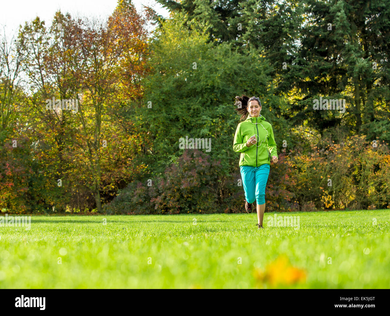 Young brunette woman running in autumn park Stock Photo - Alamy