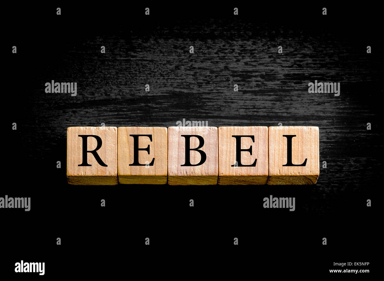 Word REBEL. Wooden small cubes with letters isolated on black ...