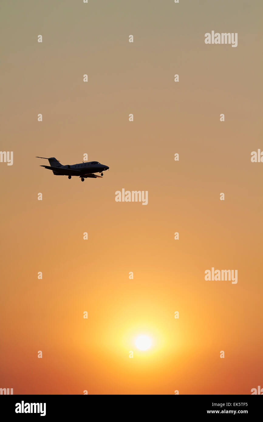 Executive jet flying in the sky at sunset Stock Photo - Alamy