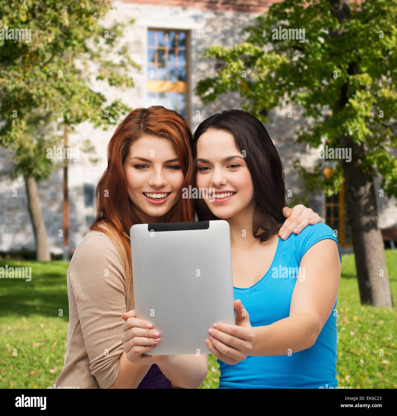 two smiling teenagers with tablet pc computer Stock Photo - Alamy