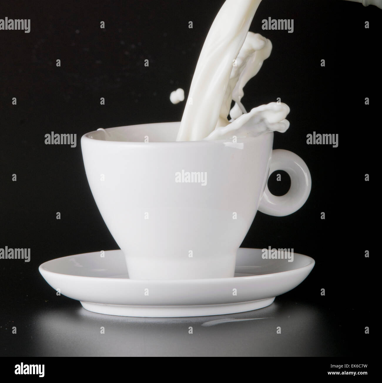 Milk splashing out of cup isolated over black background Stock Photo ...