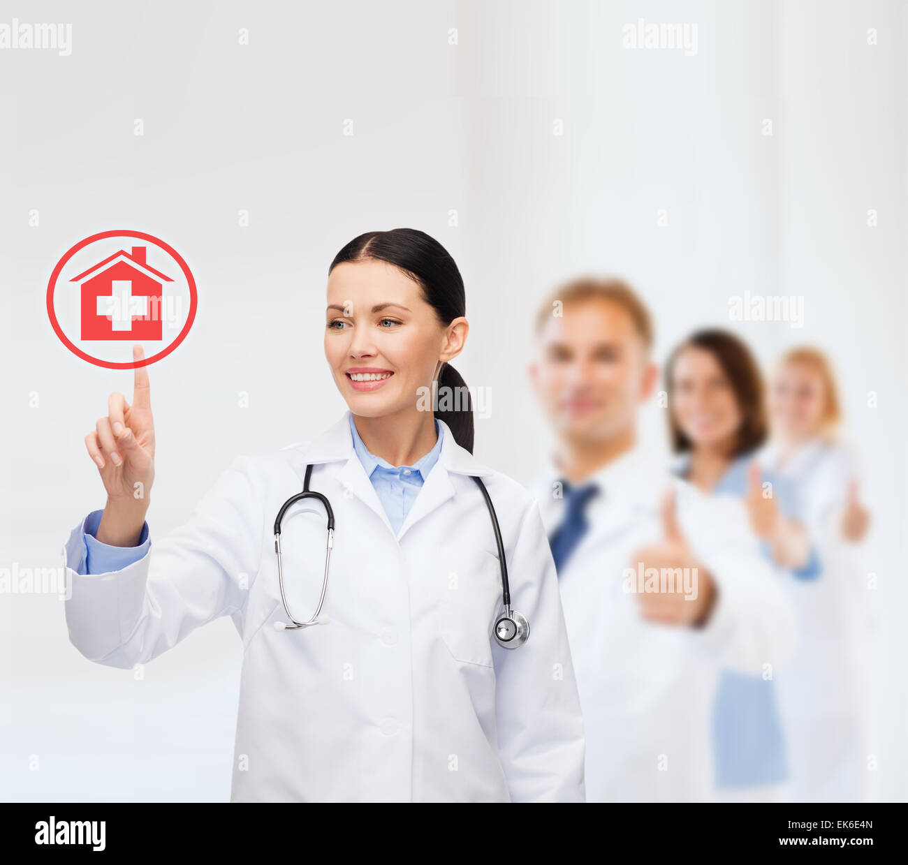 smiling female doctor pointing to something Stock Photo - Alamy