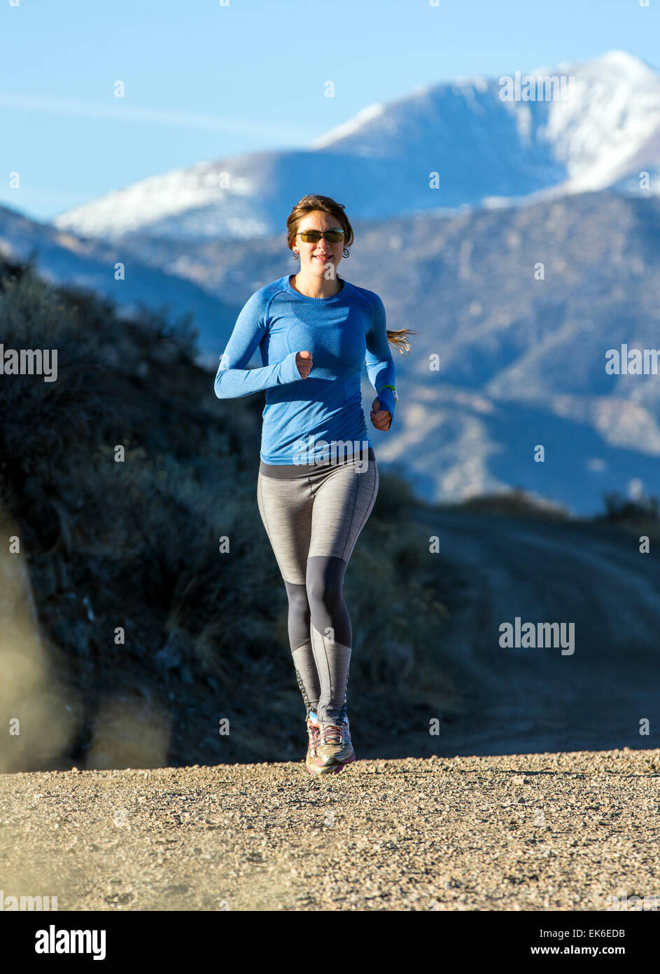 Beautiful young long haired woman running on mountain trails near ...