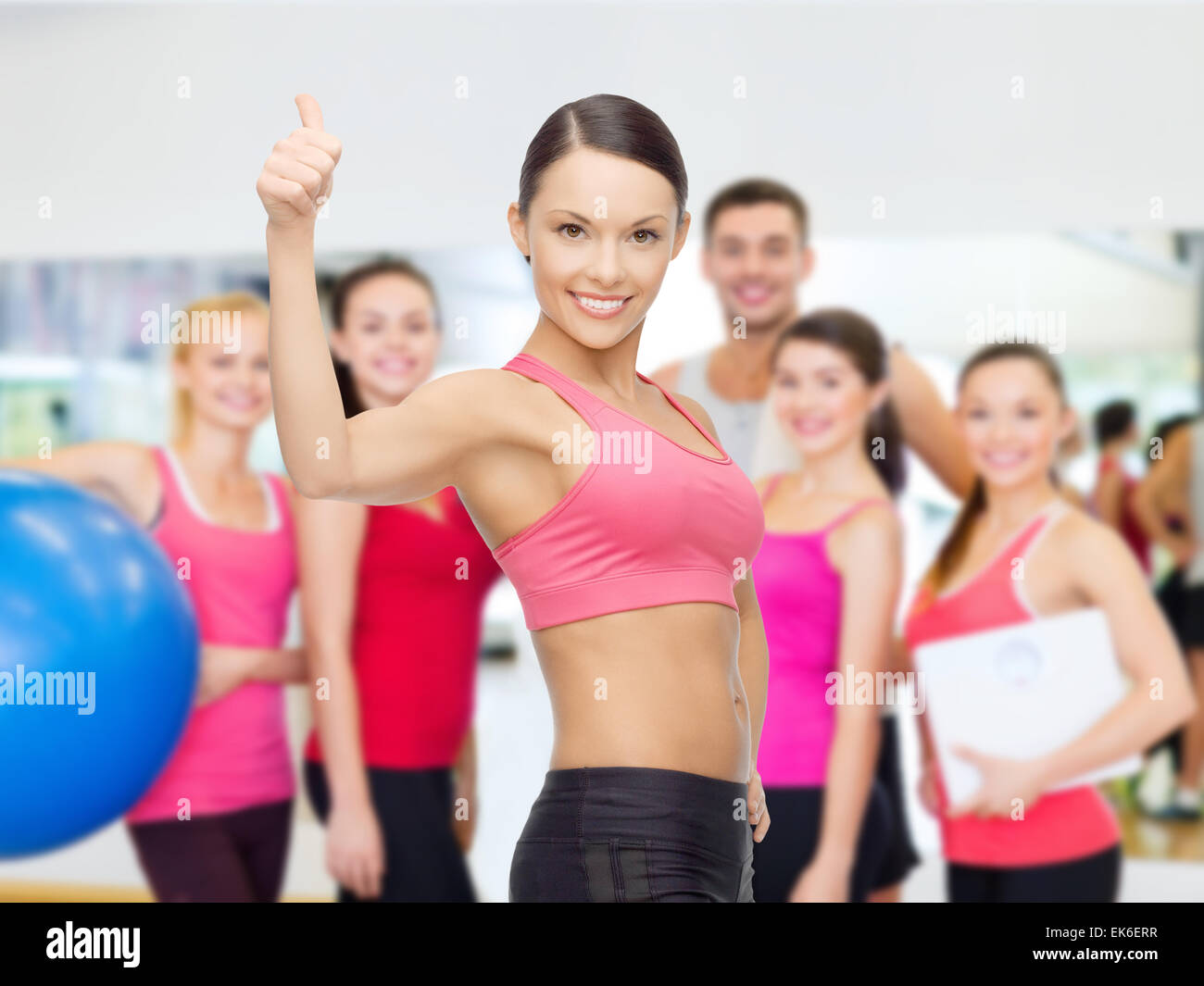 personal trainer with group in gym Stock Photo - Alamy