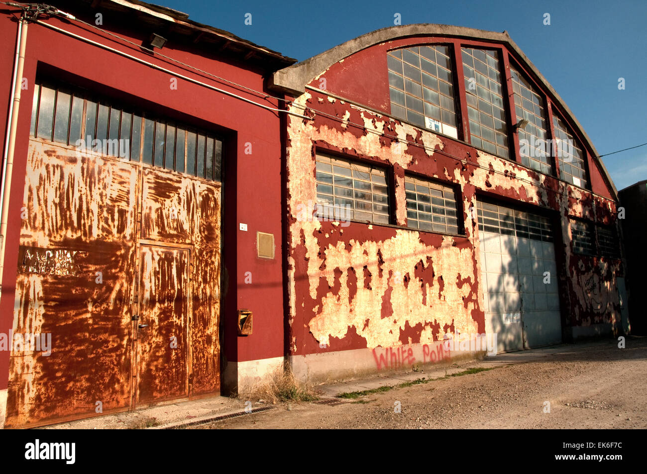 Old factory with scraped walls, rusty door and wall graffiti, Lugo (RA ...