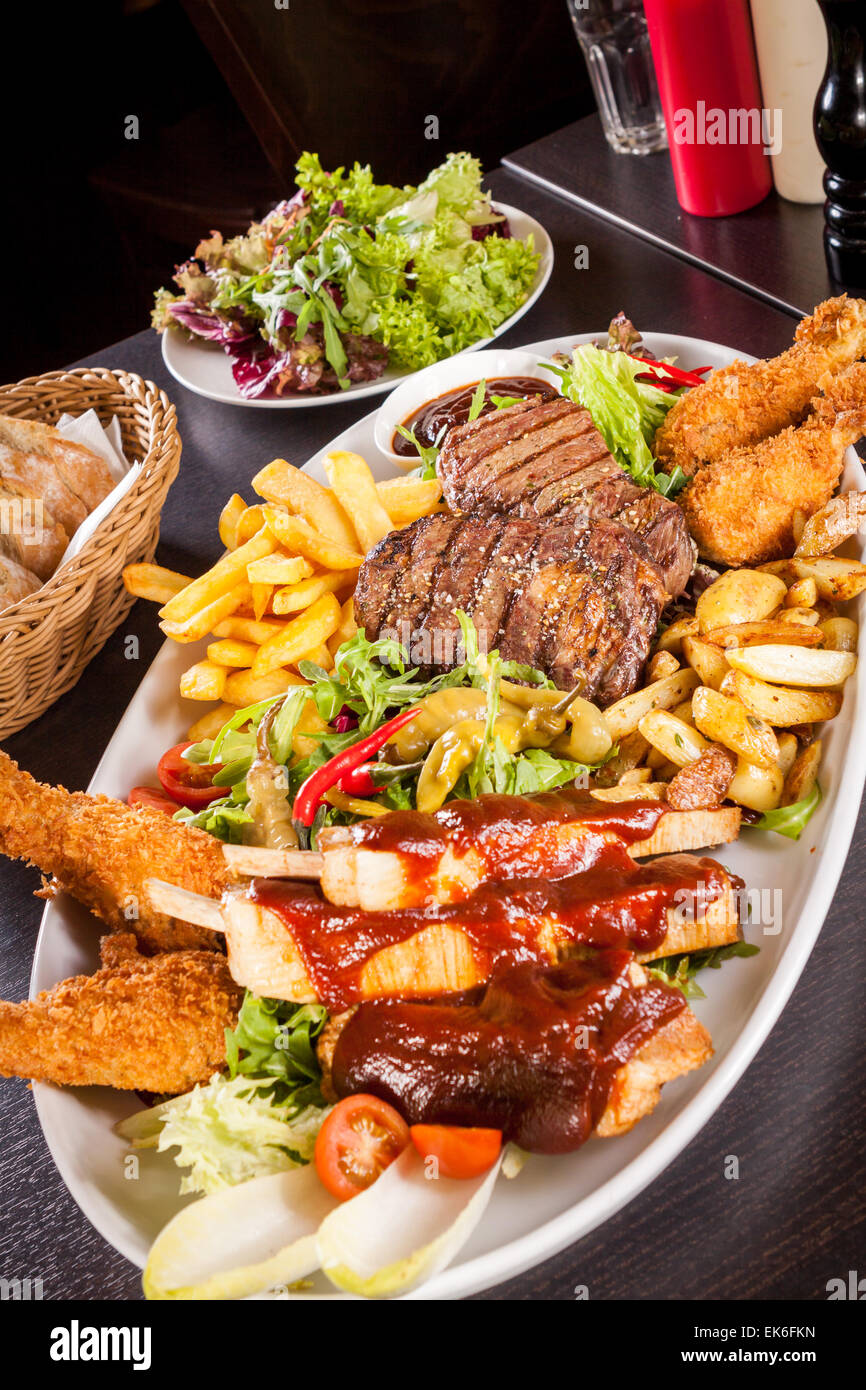 Wholesome platter of mixed meats including grilled steak, crispy ...