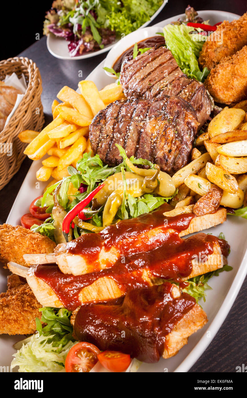 Wholesome platter of mixed meats including grilled steak, crispy ...