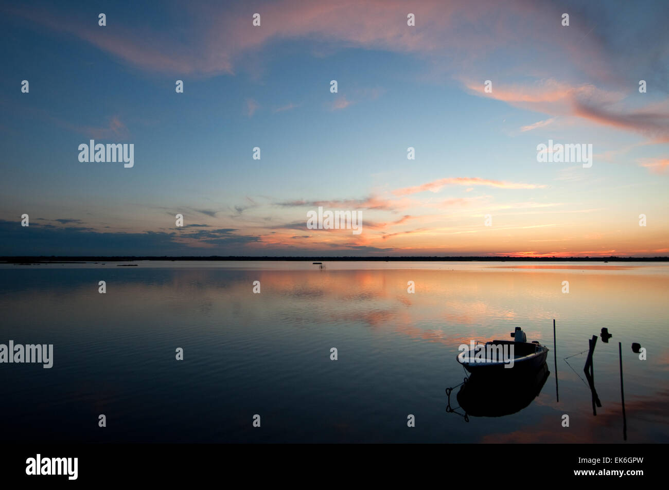 Small empty boat in a lagoon at sunset, Pialassa Baiona, Marina Romea ...