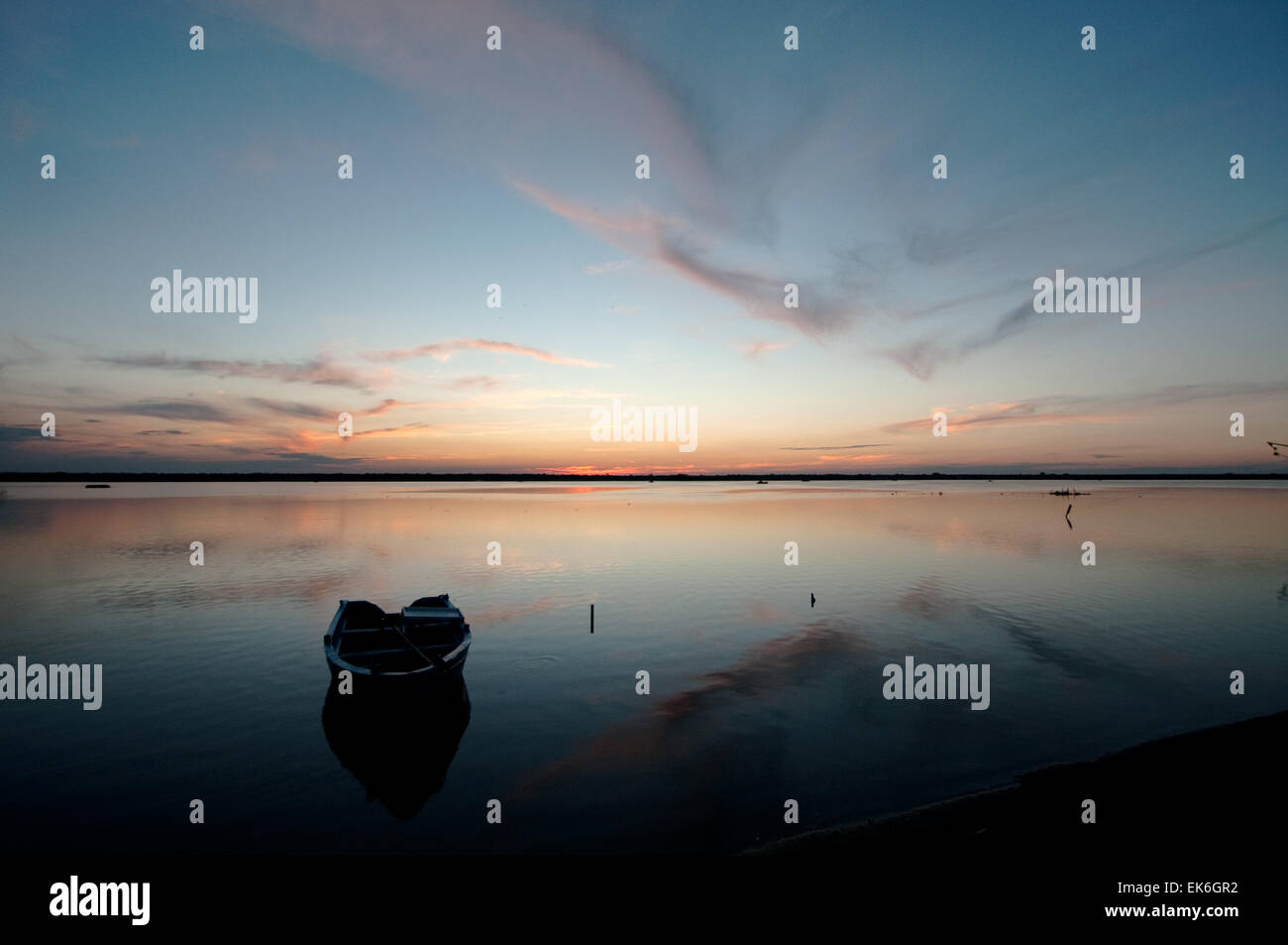 Small empty boat in a lagoon at sunset, Pialassa Baiona, Marina Romea ...