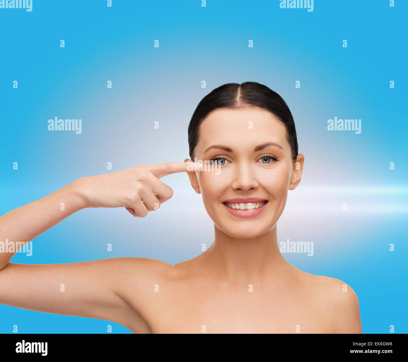 young calm woman pointing to her eye Stock Photo - Alamy