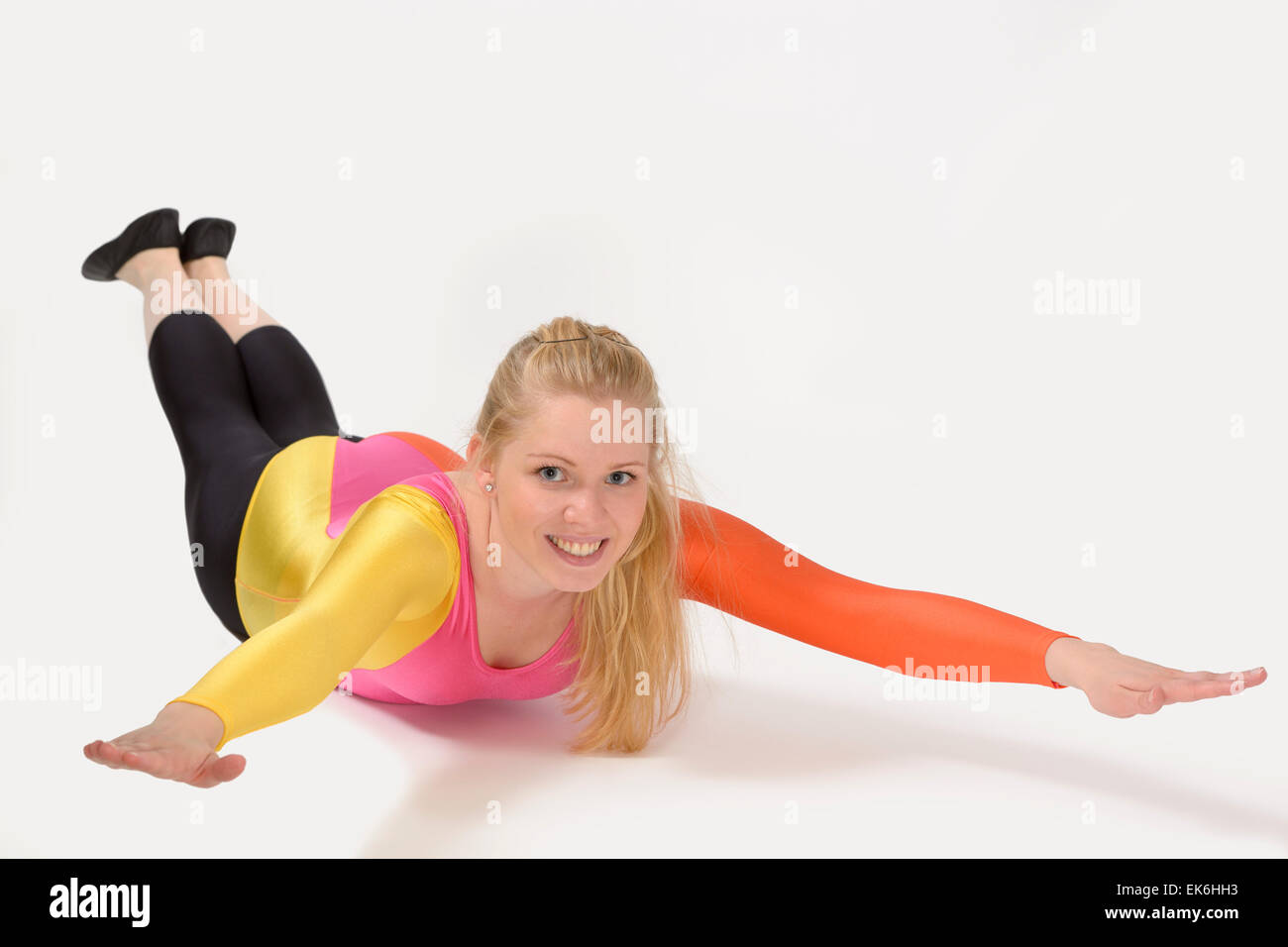 Young woman doing workout. She is wearing a shiny colorful spandex ...