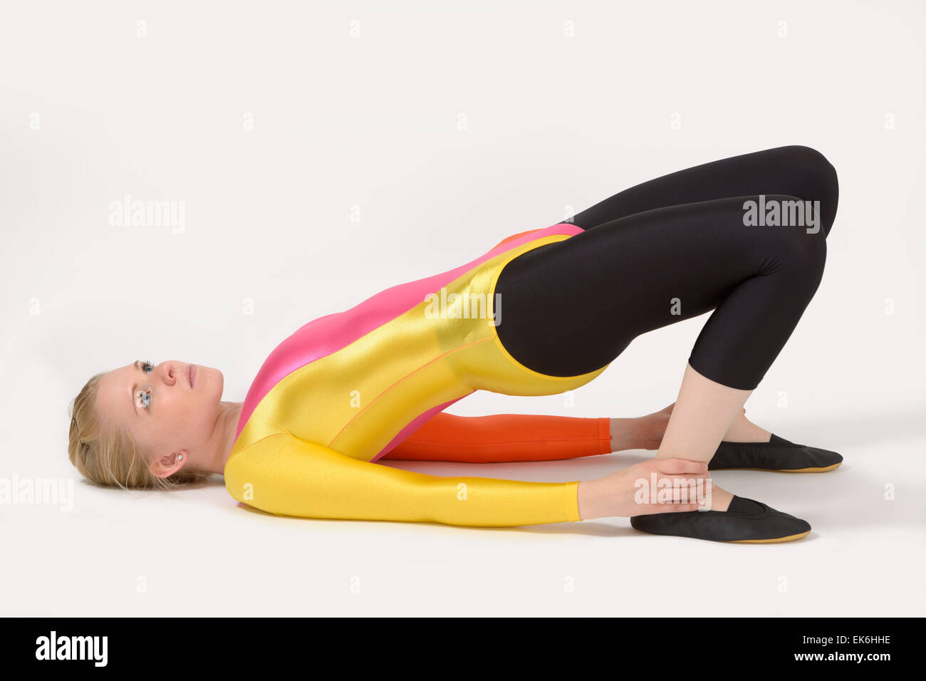 Young woman doing workout. She is wearing a shiny colorful spandex ...