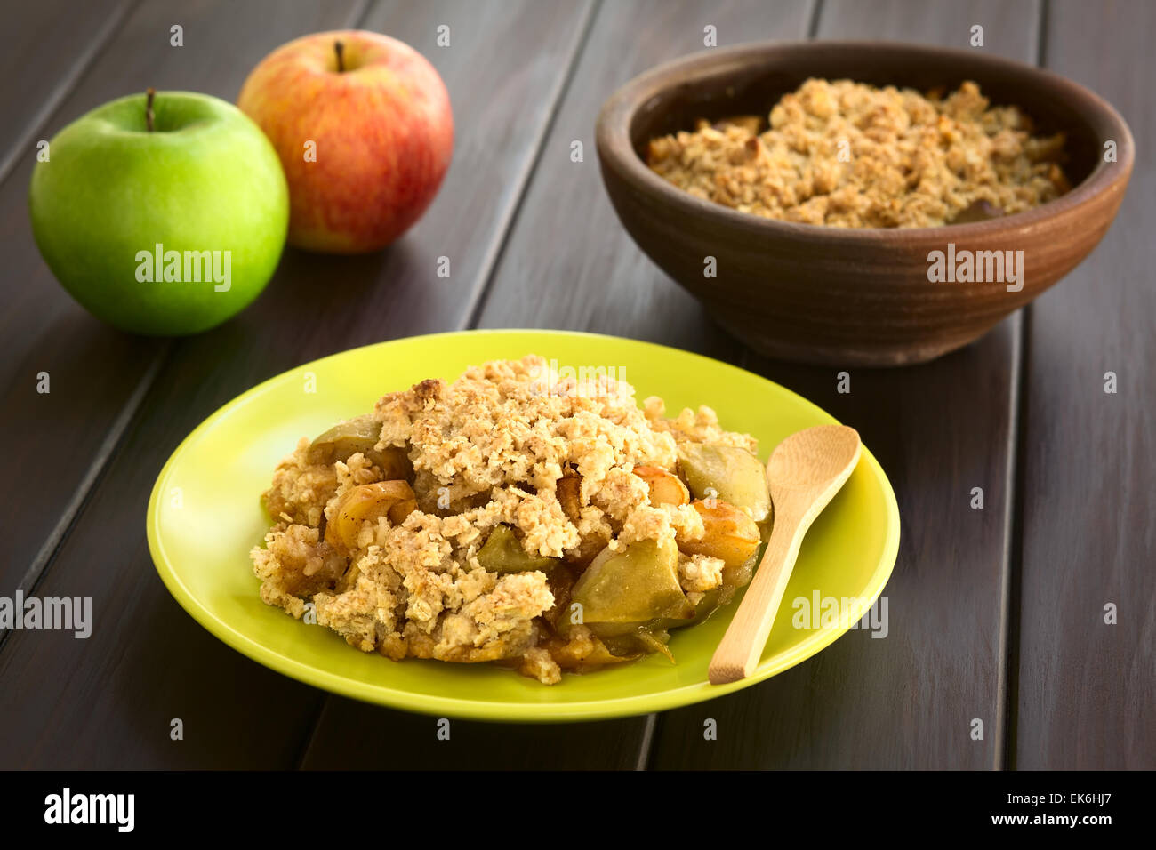 Freshly baked apple crumble or crisp served on plate with wooden spoon ...