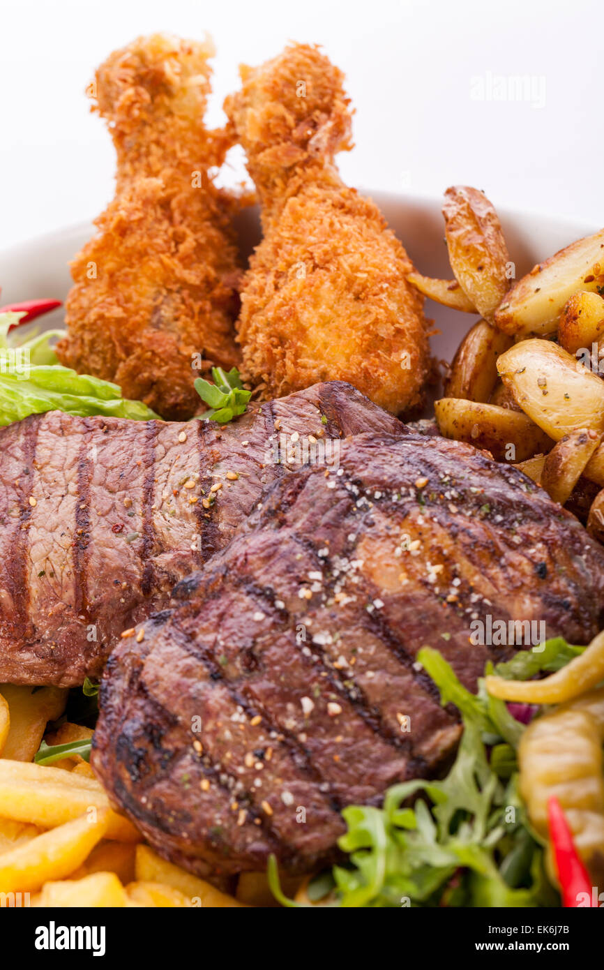 Wholesome platter of mixed meats including grilled steak, crispy ...