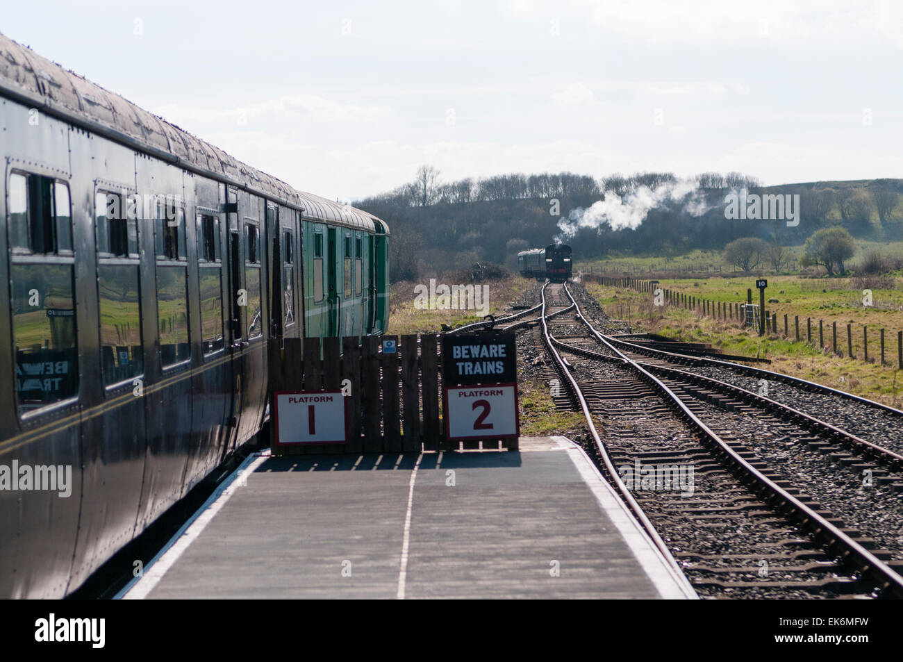 Steam train approaches a platform with another train stationary Stock ...