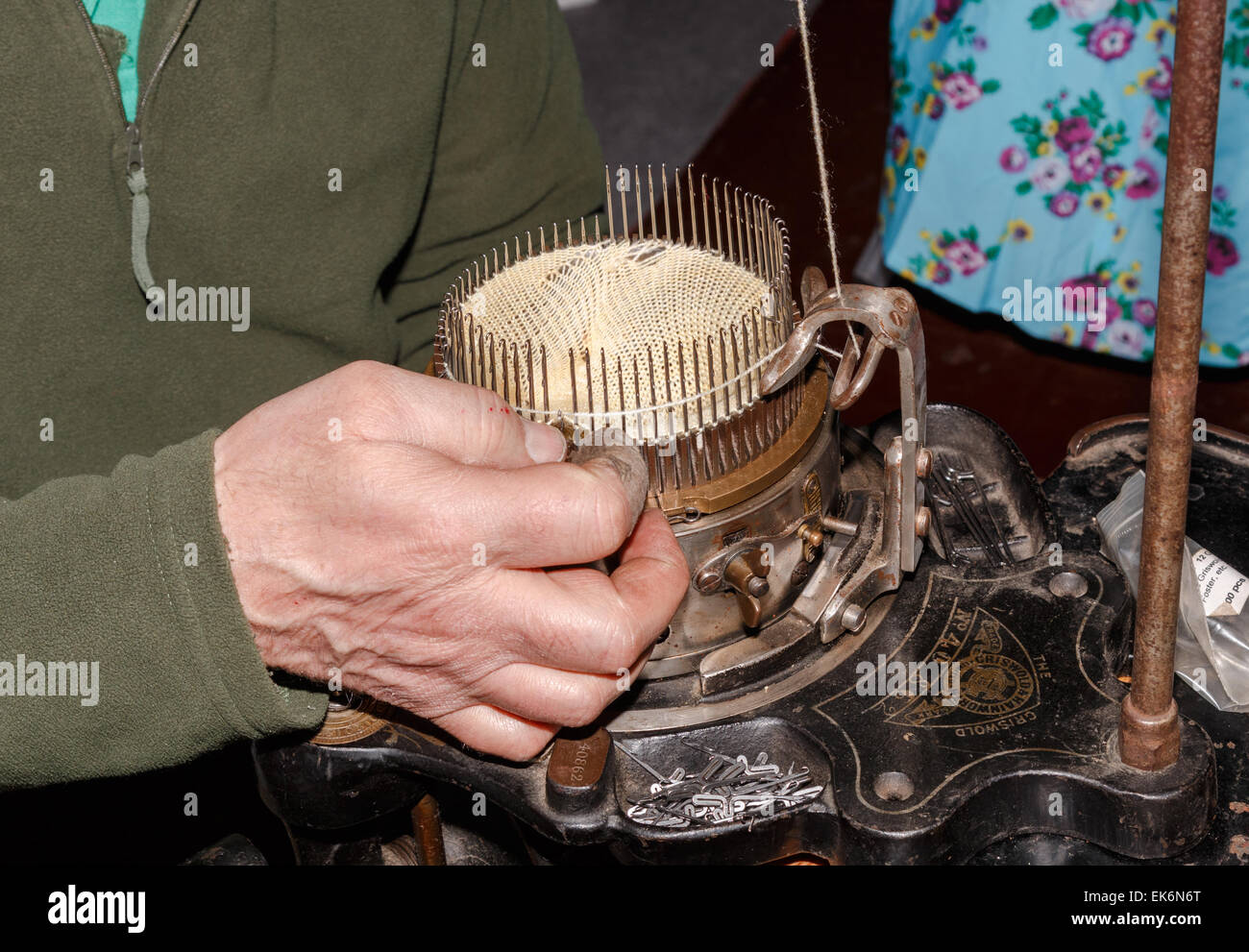 Close up of a circular sock making machine being used by a middle-aged ...