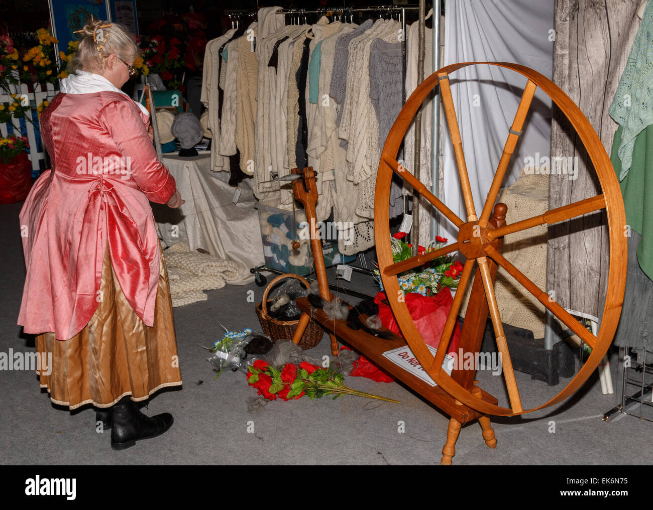 Woman (50-60 years) spinner in traditional costume using a hand driven ...