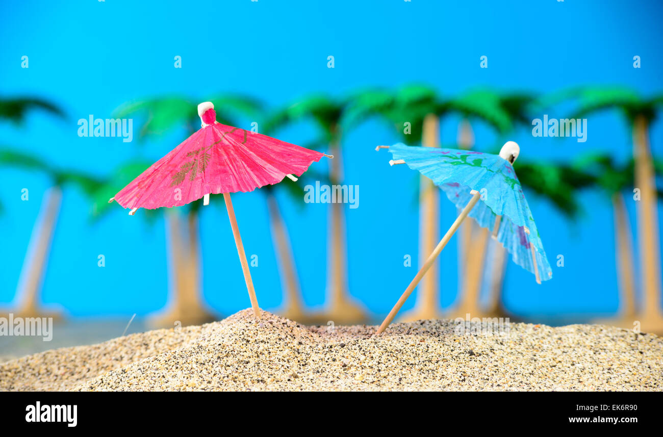 two small umbrellas on a beach with palm trees Stock Photo - Alamy
