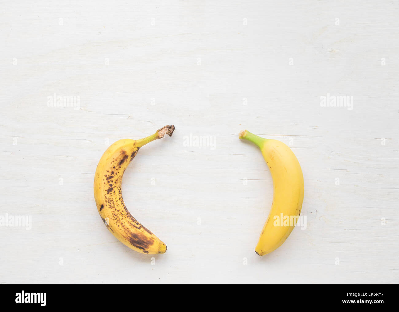 New versus old: two facing bananas, one fresh and another ripe one ...