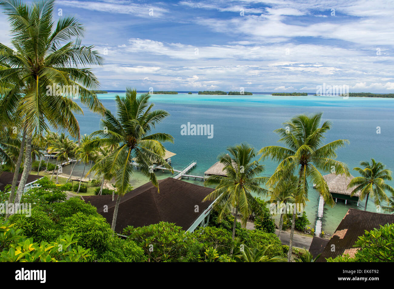 Palm Trees overlooking a beach and bungalows over water Stock Photo - Alamy