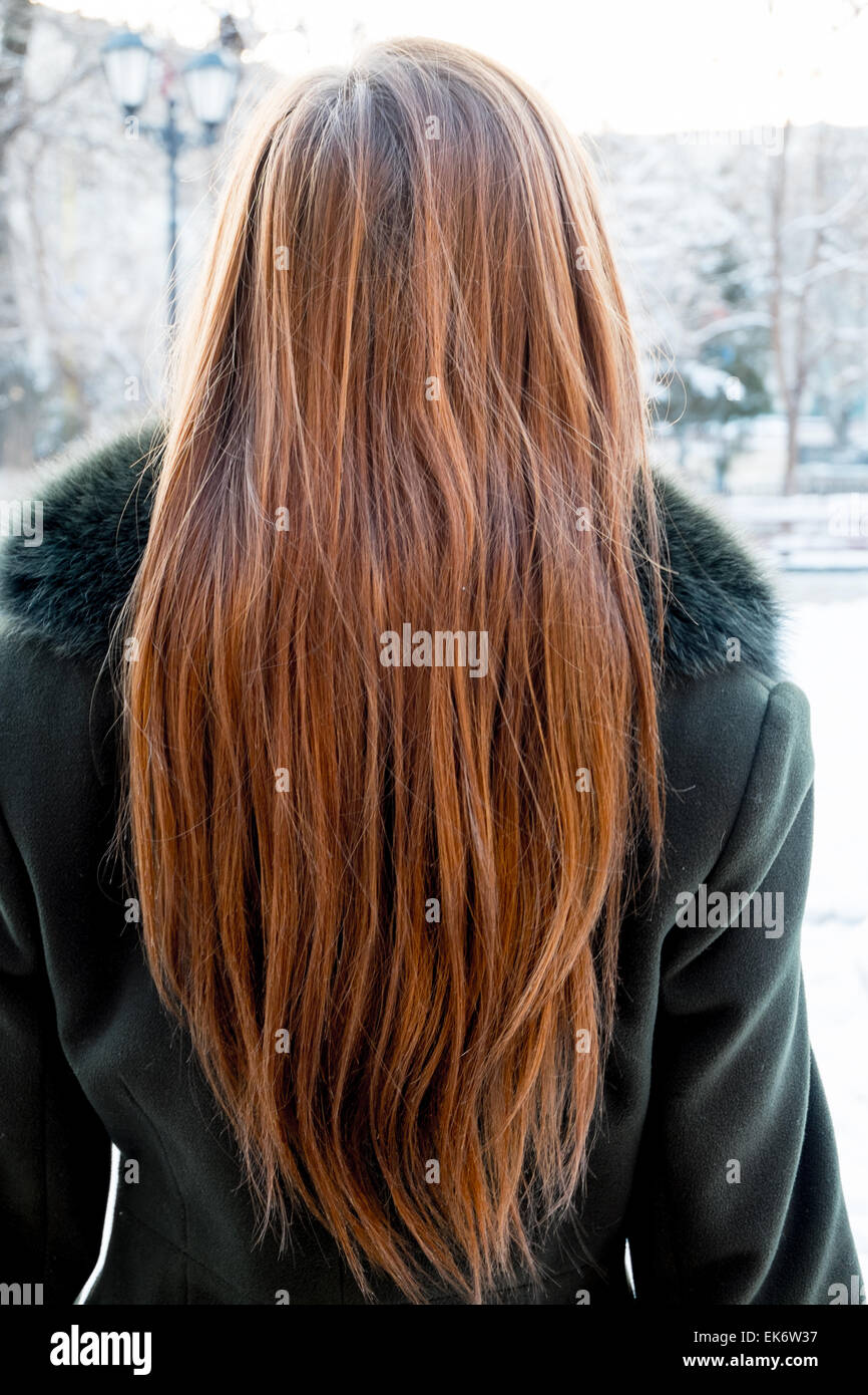 Redhead in winter. Rear view of a young woman with red hair in the ...