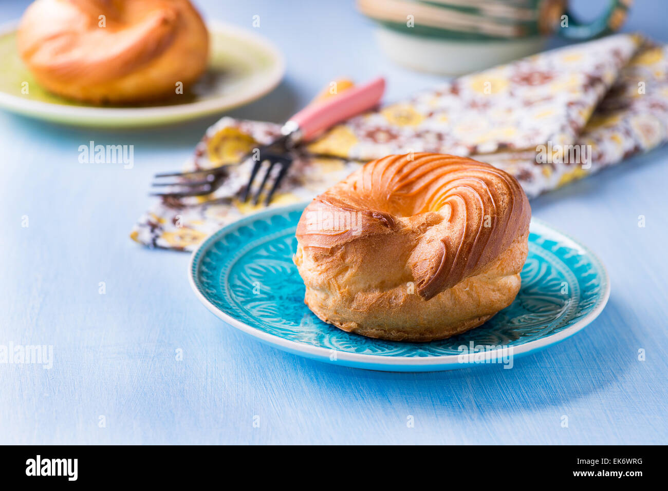 Choux pastry eclair ring with custard cream served for tea, selective ...
