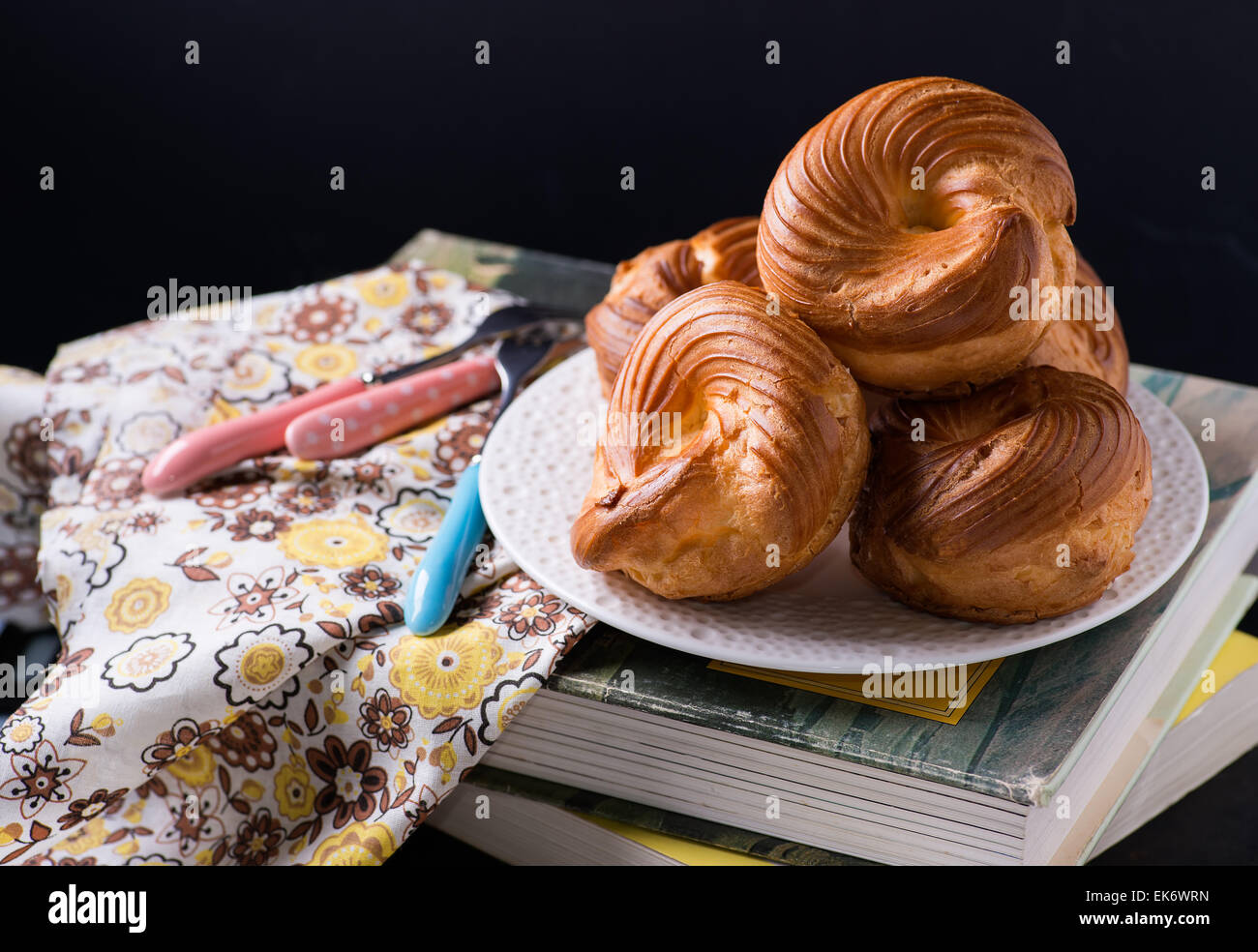 Choux pastry eclair ring with custard cream on dark background ...