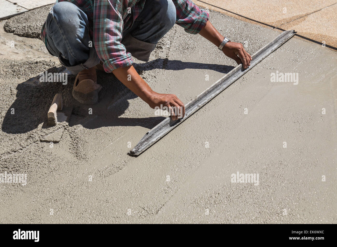Construction worker spreading wet concrete on the ground Stock Photo ...