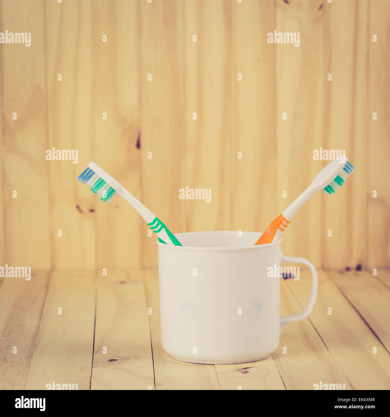Toothbrushes in cup on wooden table with retro filter effect Stock ...