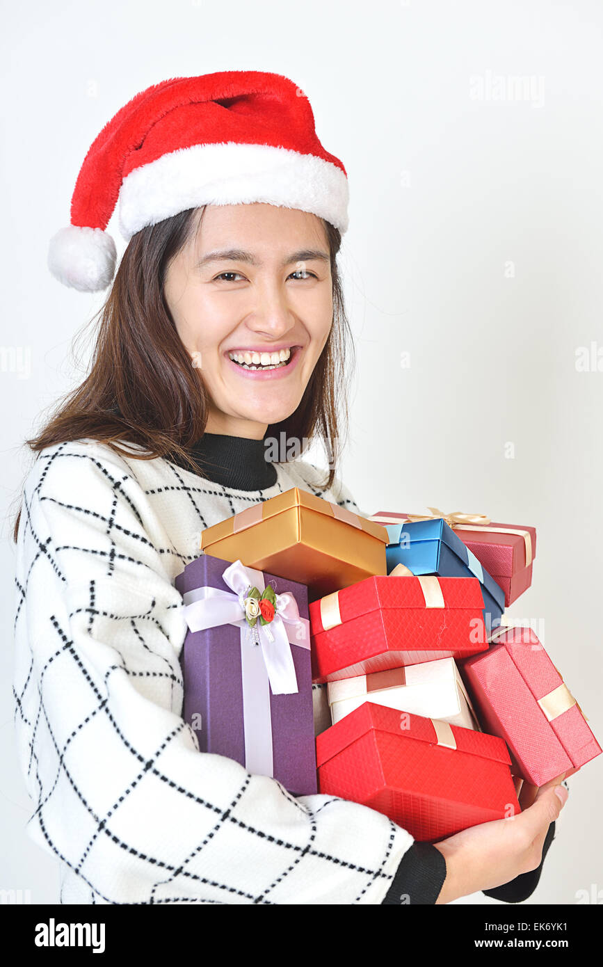 Asian woman with an armful of presents after going Christmas shopping ...