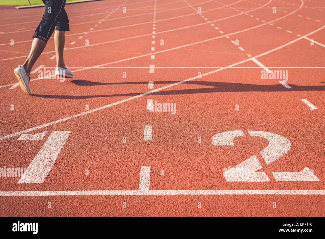 Running track with number and legs of runner Stock Photo - Alamy