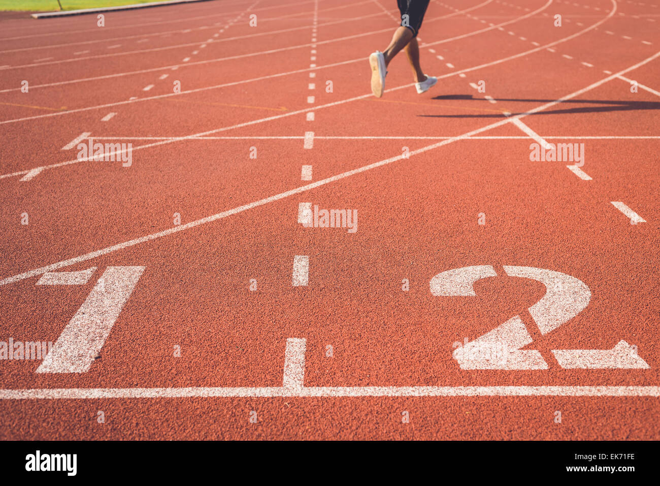 Running track with number and legs of runner Stock Photo - Alamy