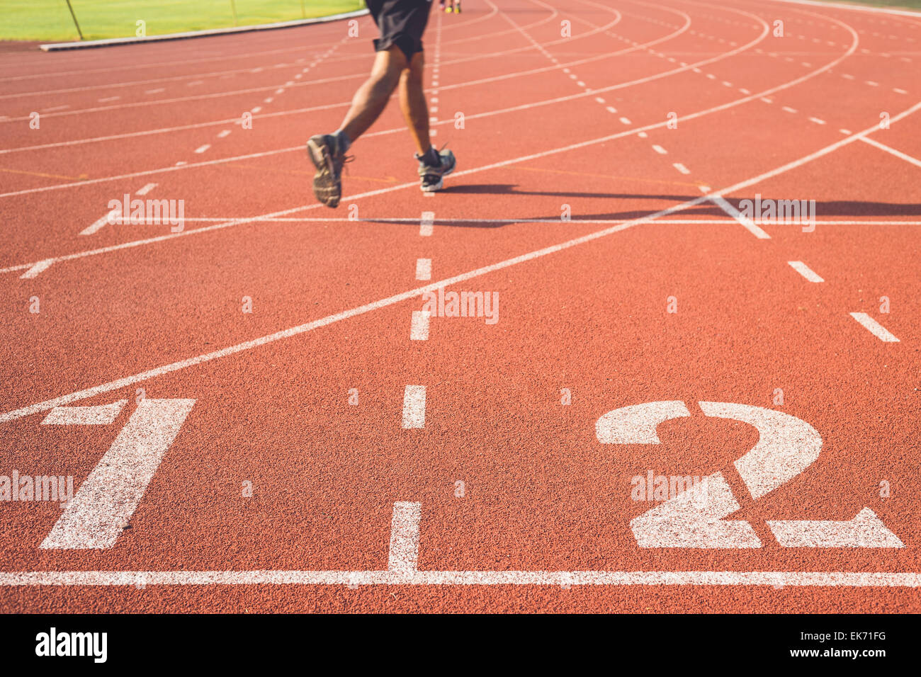 Running track with number and legs of runner Stock Photo - Alamy