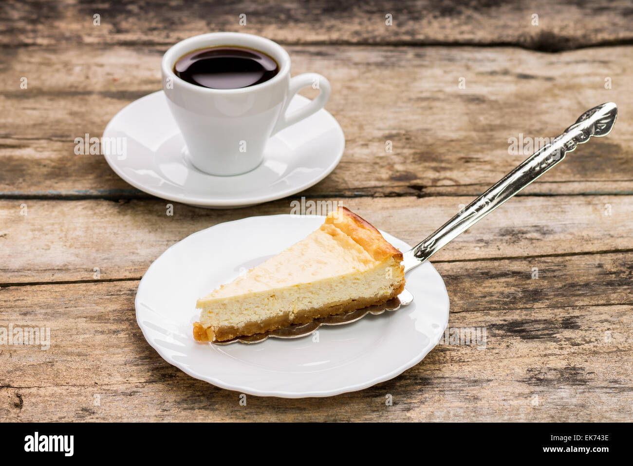 Cheesecake with cake server and cup of coffee on wooden table. desser ...