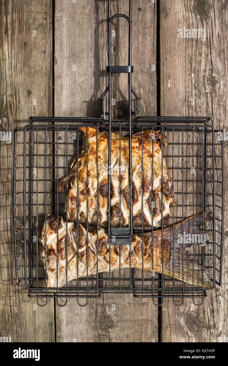 Grilled fish in barbecue on wood background. Outdoor activity eating ...