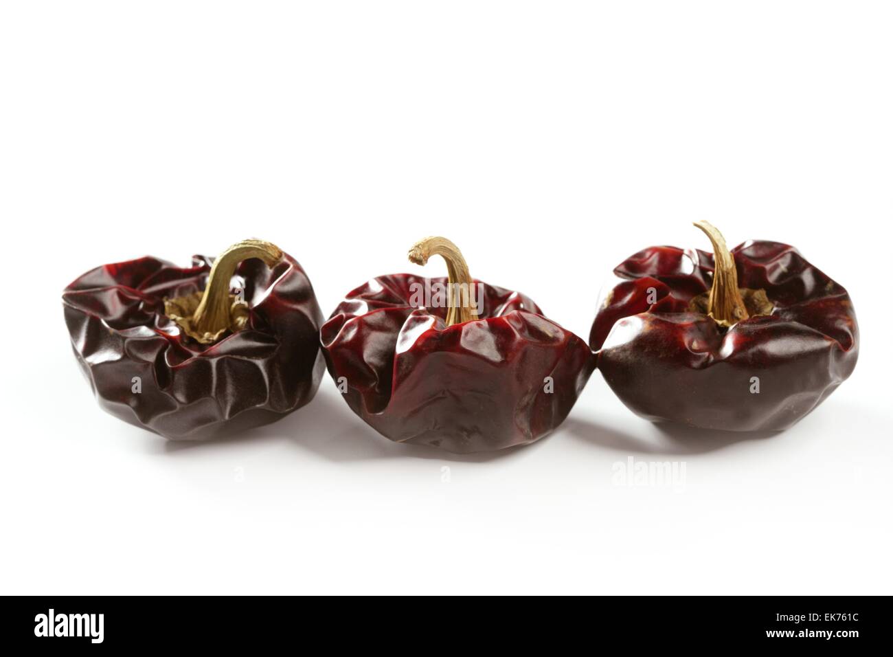 Three round Mediterranean dried dark red peppers Stock Photo - Alamy