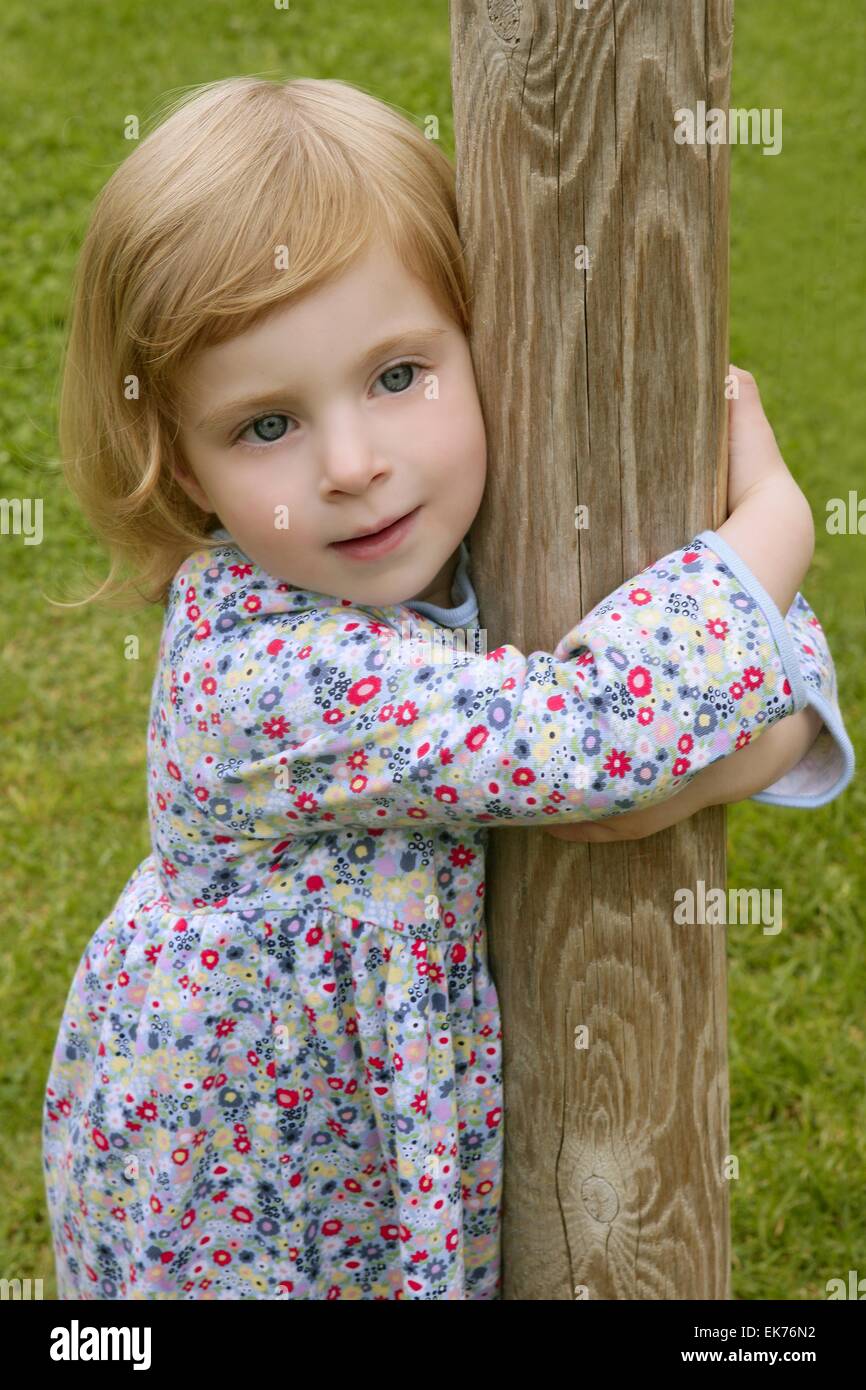 Beautiful little toddler girl hug a trunk Stock Photo - Alamy